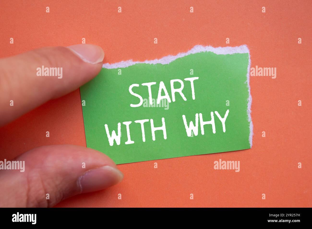 Start with why message written on ripped green torn paper with orange background. Conceptual ...
