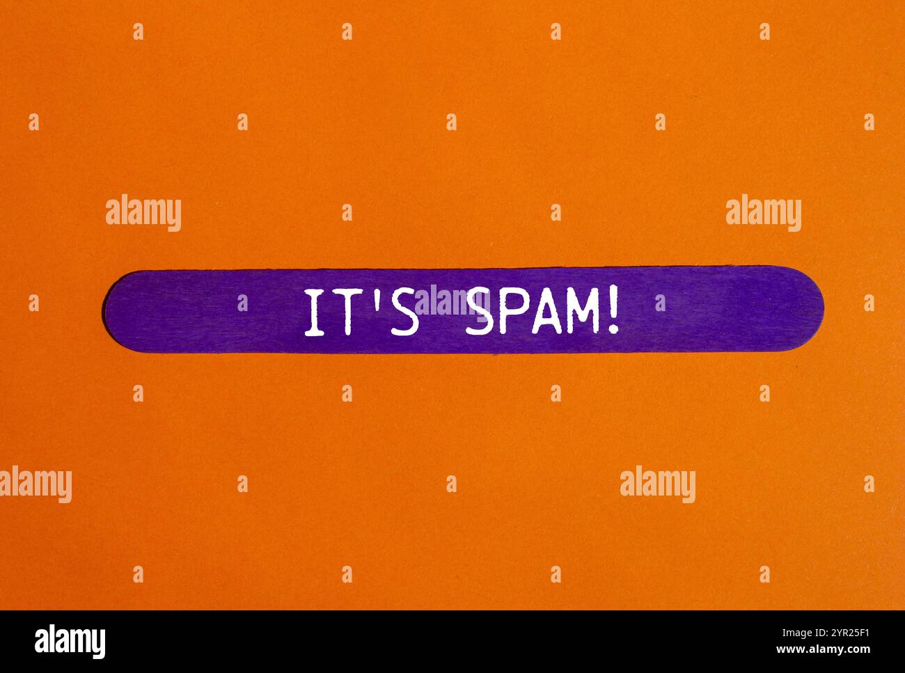 It's spam message written on purple wooden stick with orange background ...