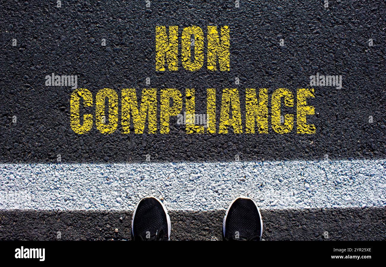 Non compliance message written on asphalt road. Conceptual non ...