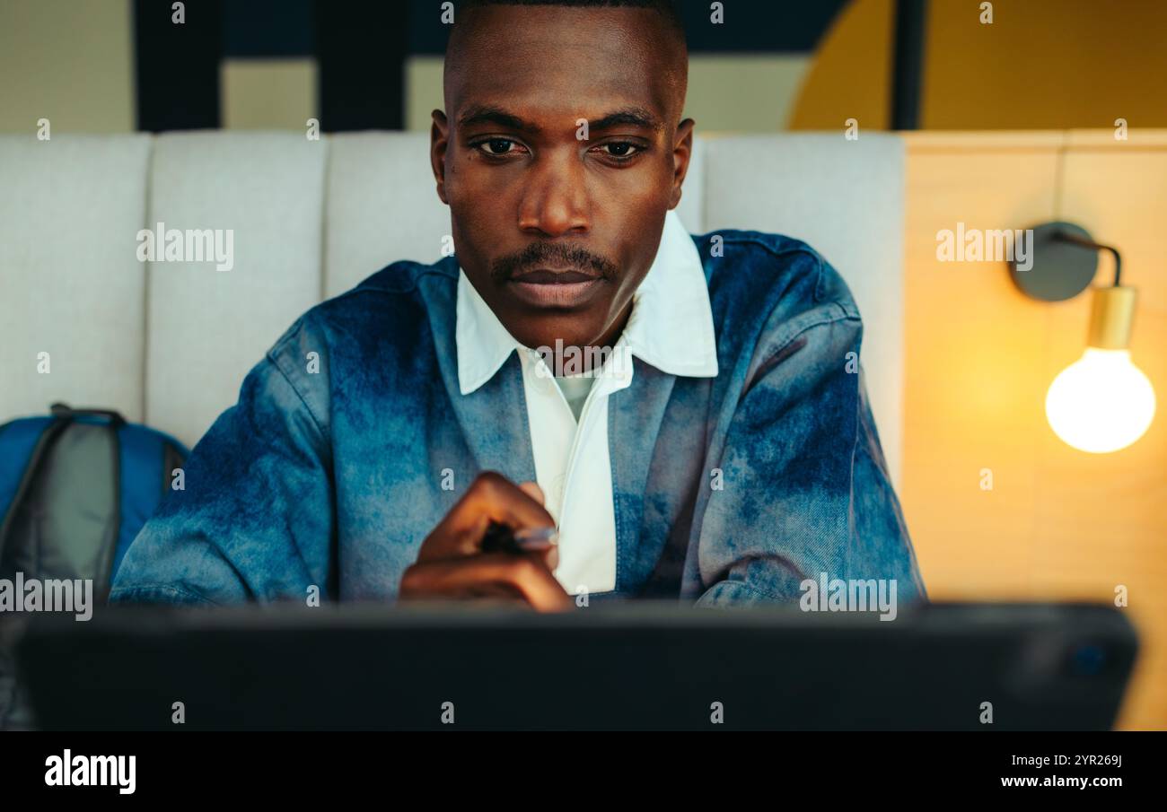 A determined male student is intensely studying in a library setting ...