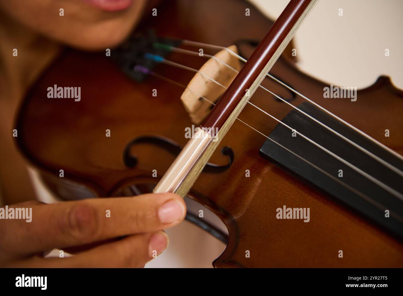 A detailed close-up of a hand expertly playing a violin, highlighting ...