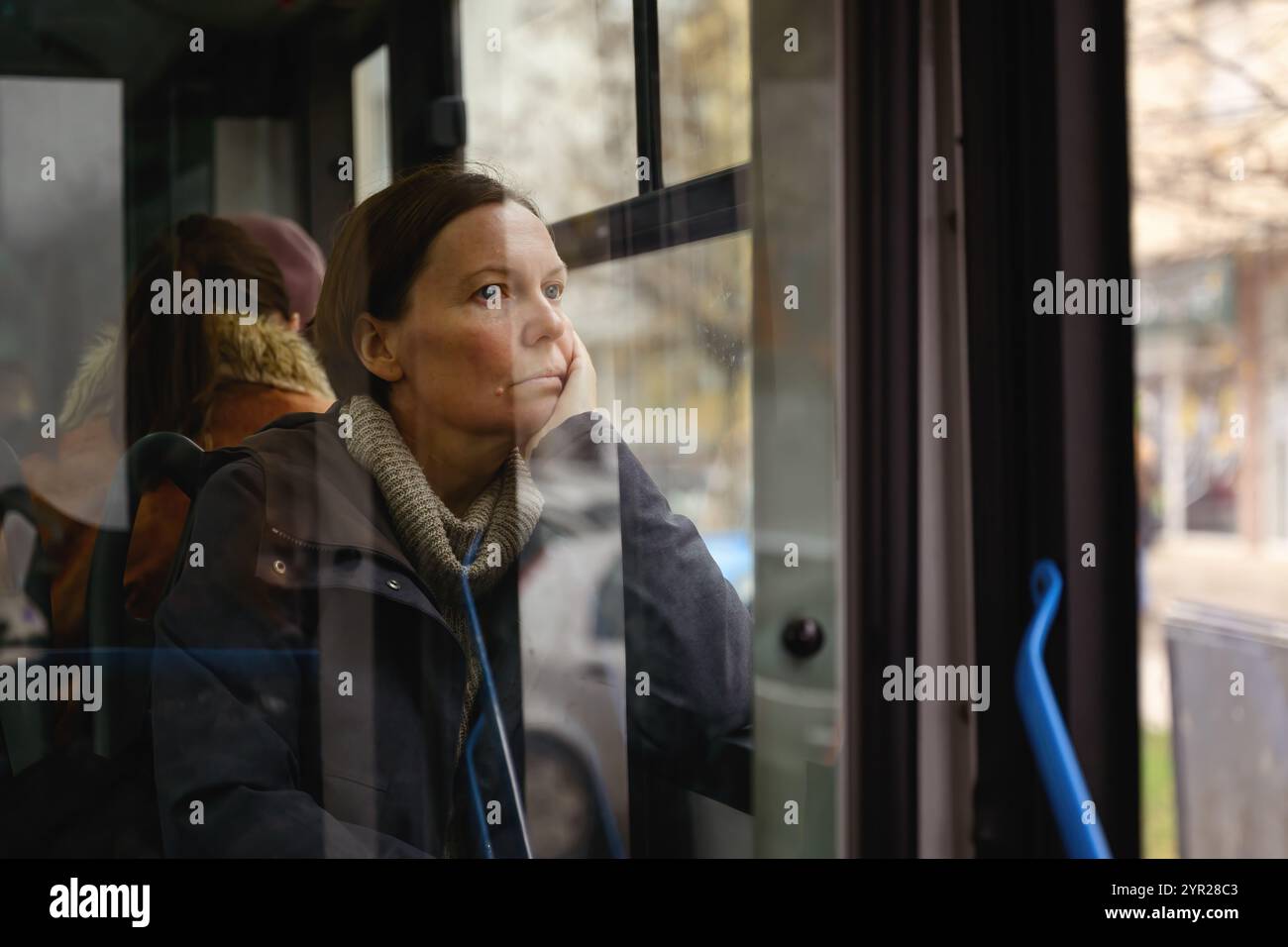 Sad and contemplative woman riding a dirty public transportation bus ...