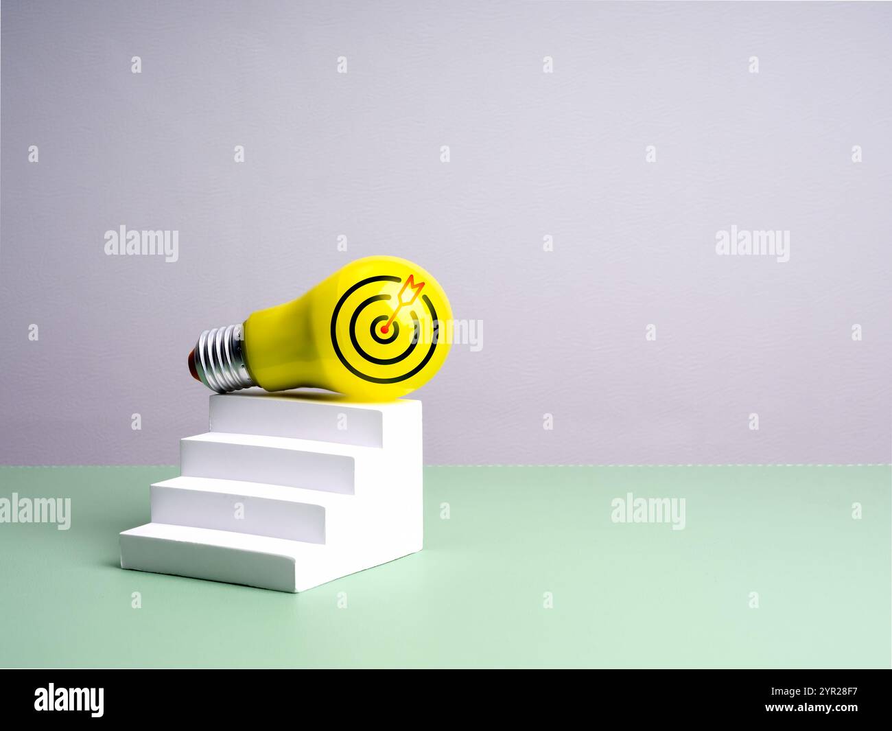 Target icon on yellow electric lightbulb, on top of white staircase ...