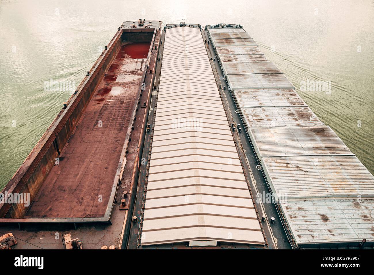 A barge, flat-bottomed boat, pushed by tugboat along the river for ...