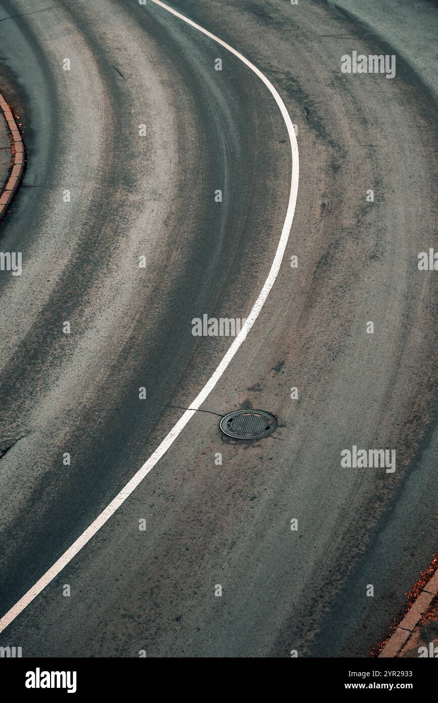 Top view of asphalt highway road with sewage manhole as background and ...