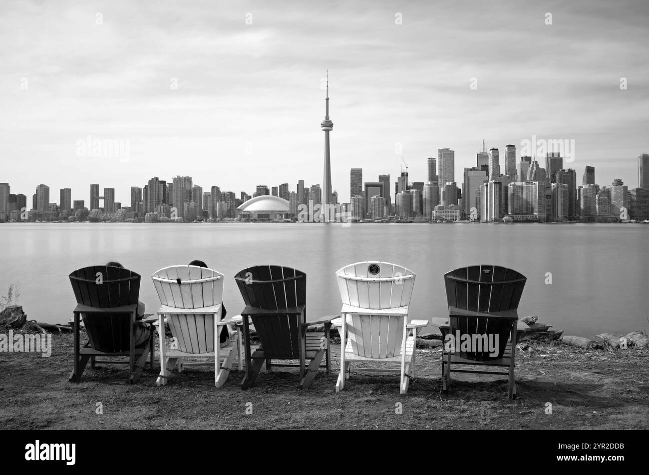 A black and white view of five Adirondack chairs overlooking the ...