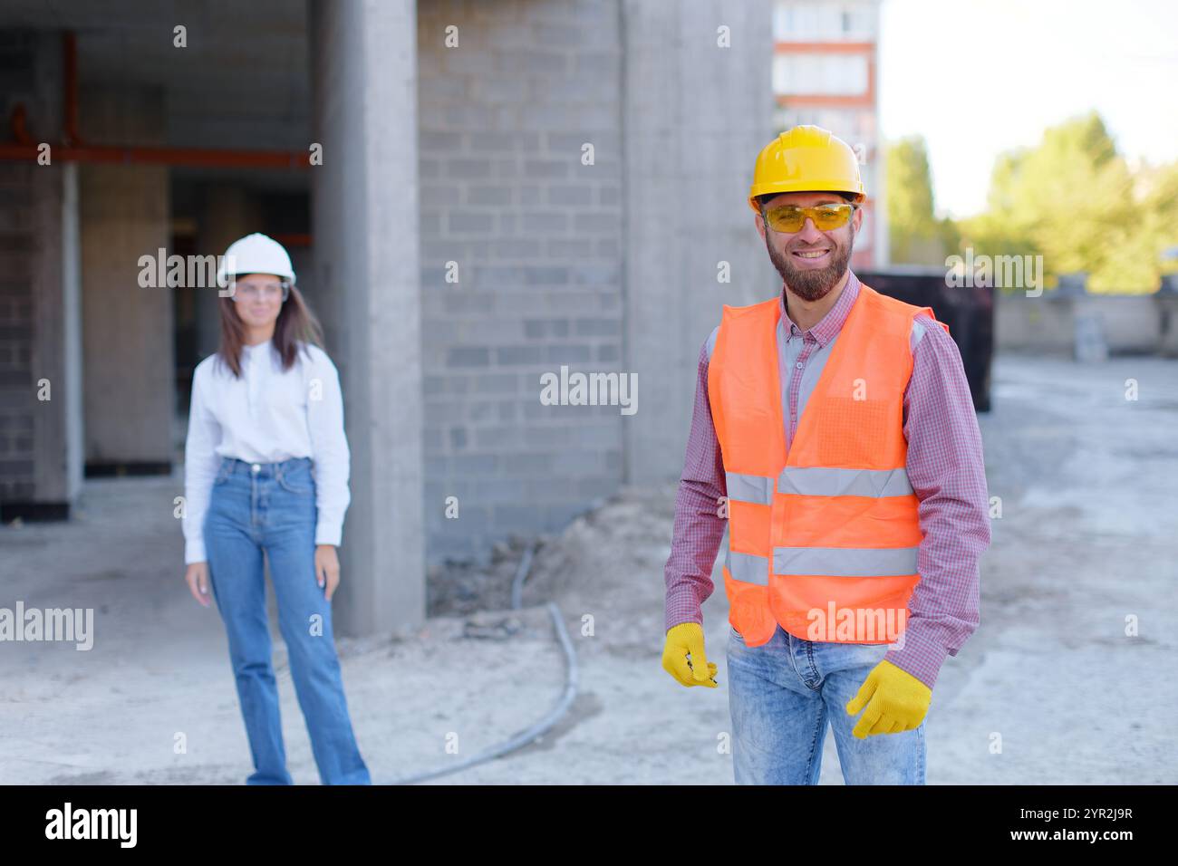Construction workers in safety gear collaborate at a busy site ...