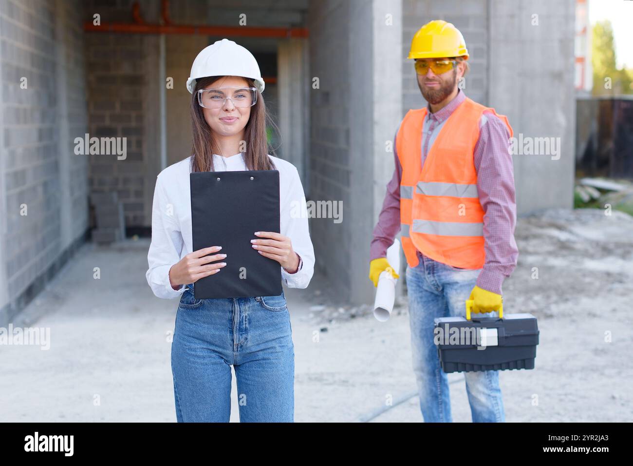 Diverse construction team in safety gear discussing project at construction site. Collaboration ...