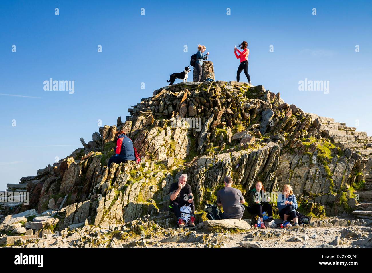 UK, Wales, Gwynedd, Snowdonia, Mount Snowdon summit, walkers on cairn ...