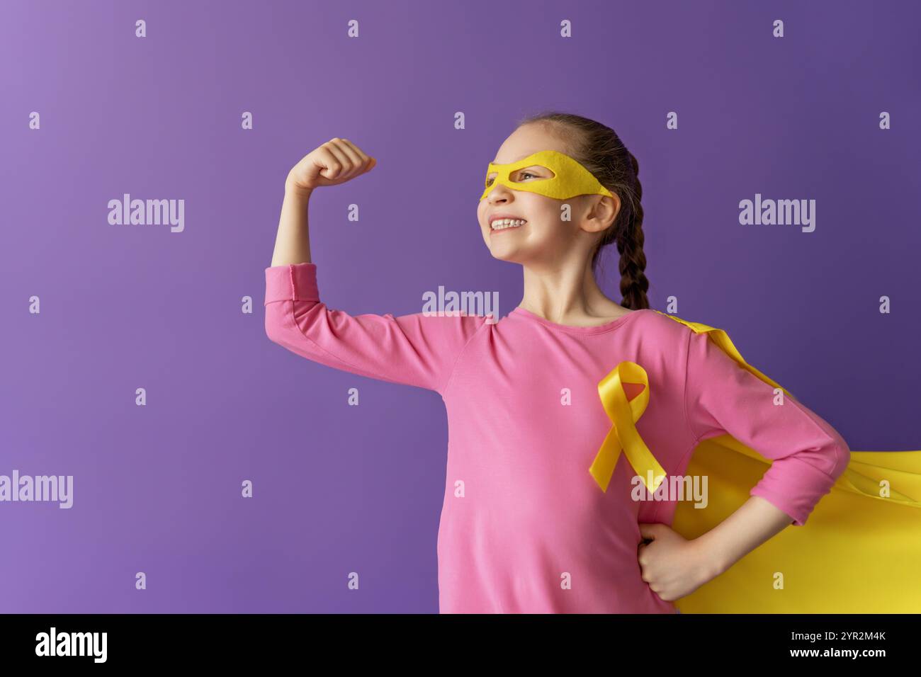 World Childhood cancer Day. Girl in superhero costume with golden ...