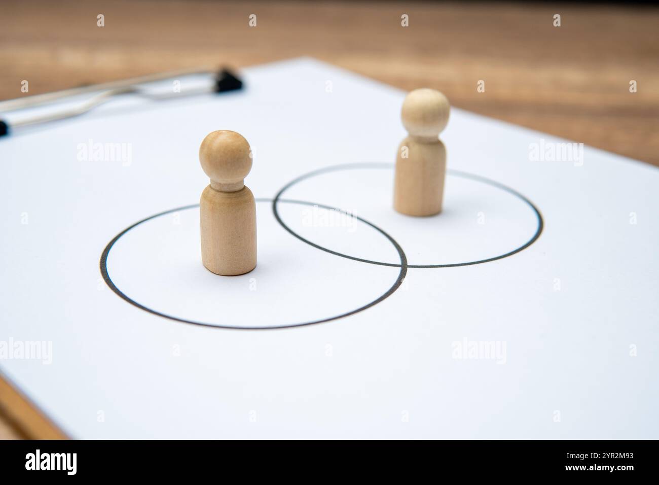 Two wooden figures standing in separate circles overlaps with each ...