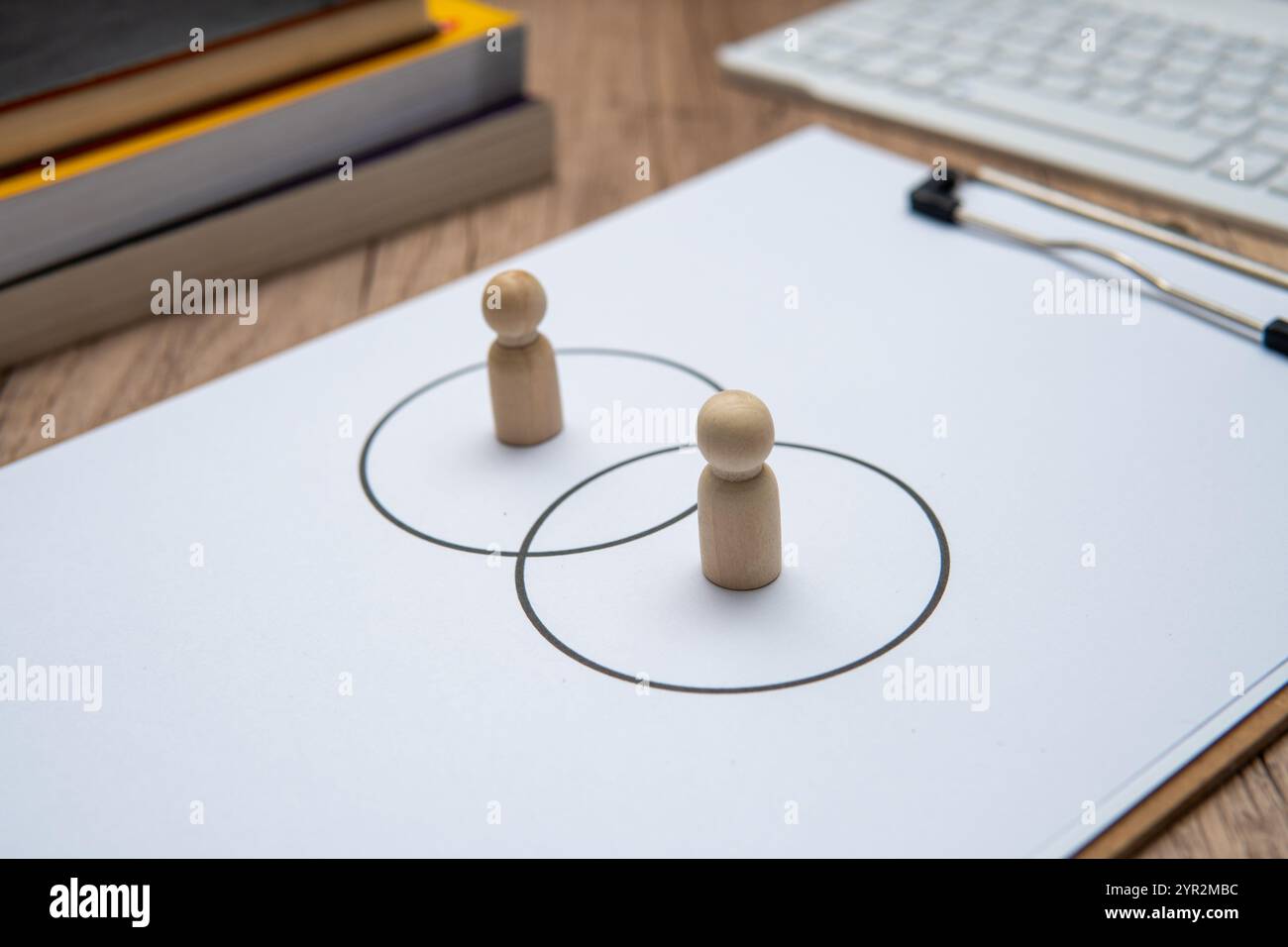 Two wooden figures standing in separate circles overlaps with each ...