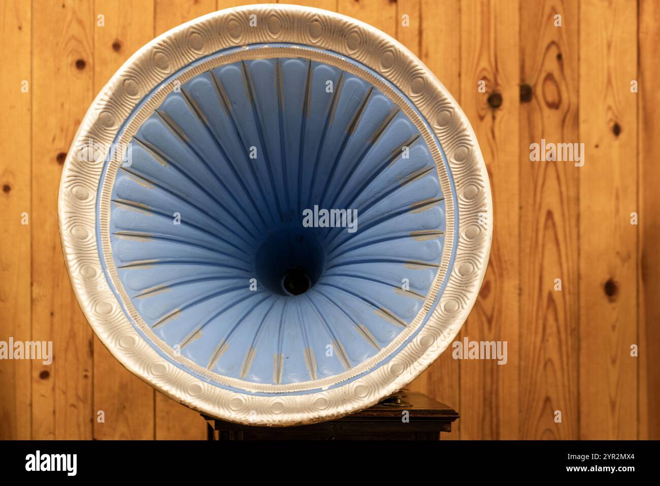 Decorated blue gramophone speaker is over wooden wall, close up photo ...