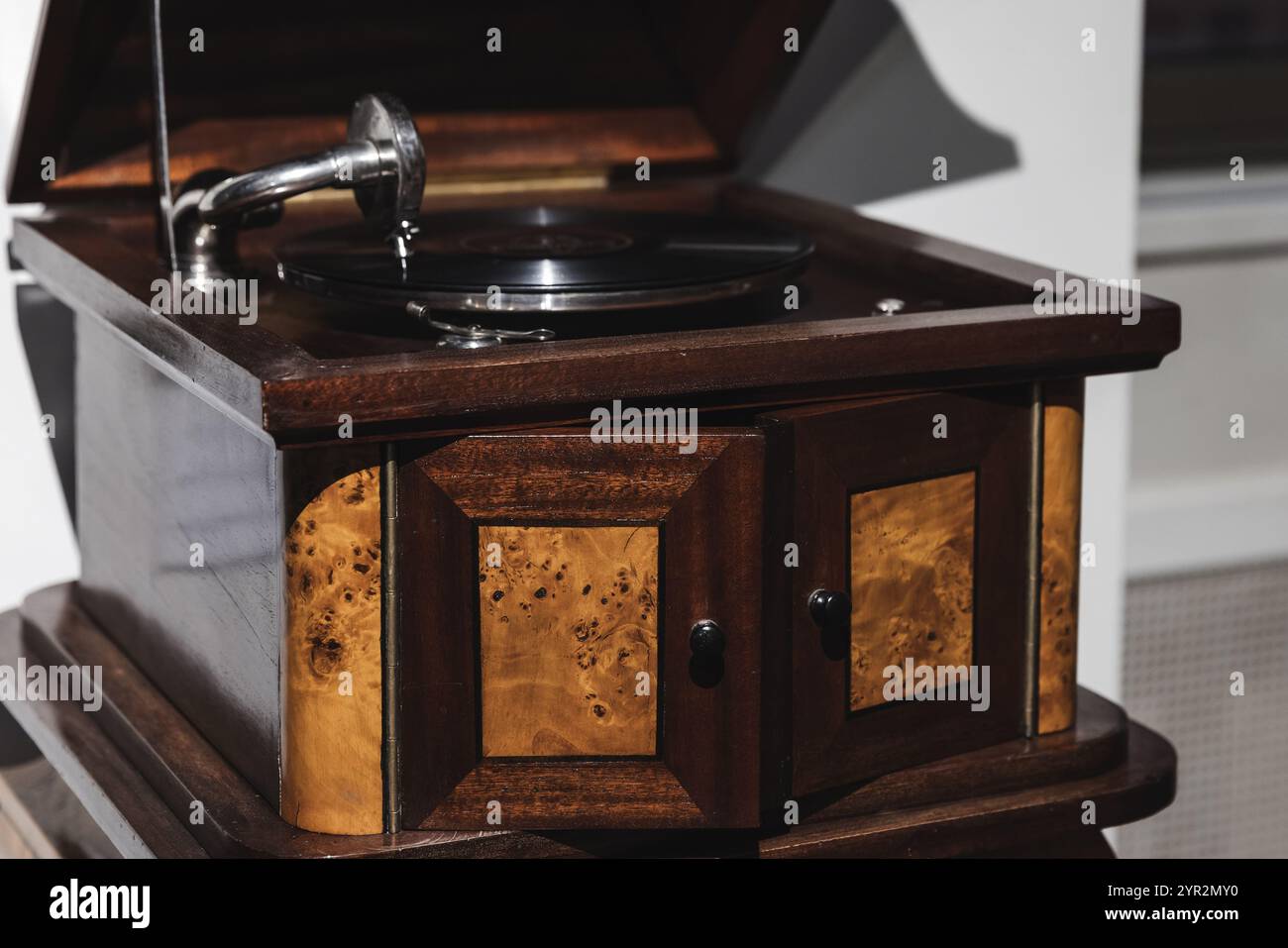 Vintage phonograph with wooden body and black vinyl record plays an old ...