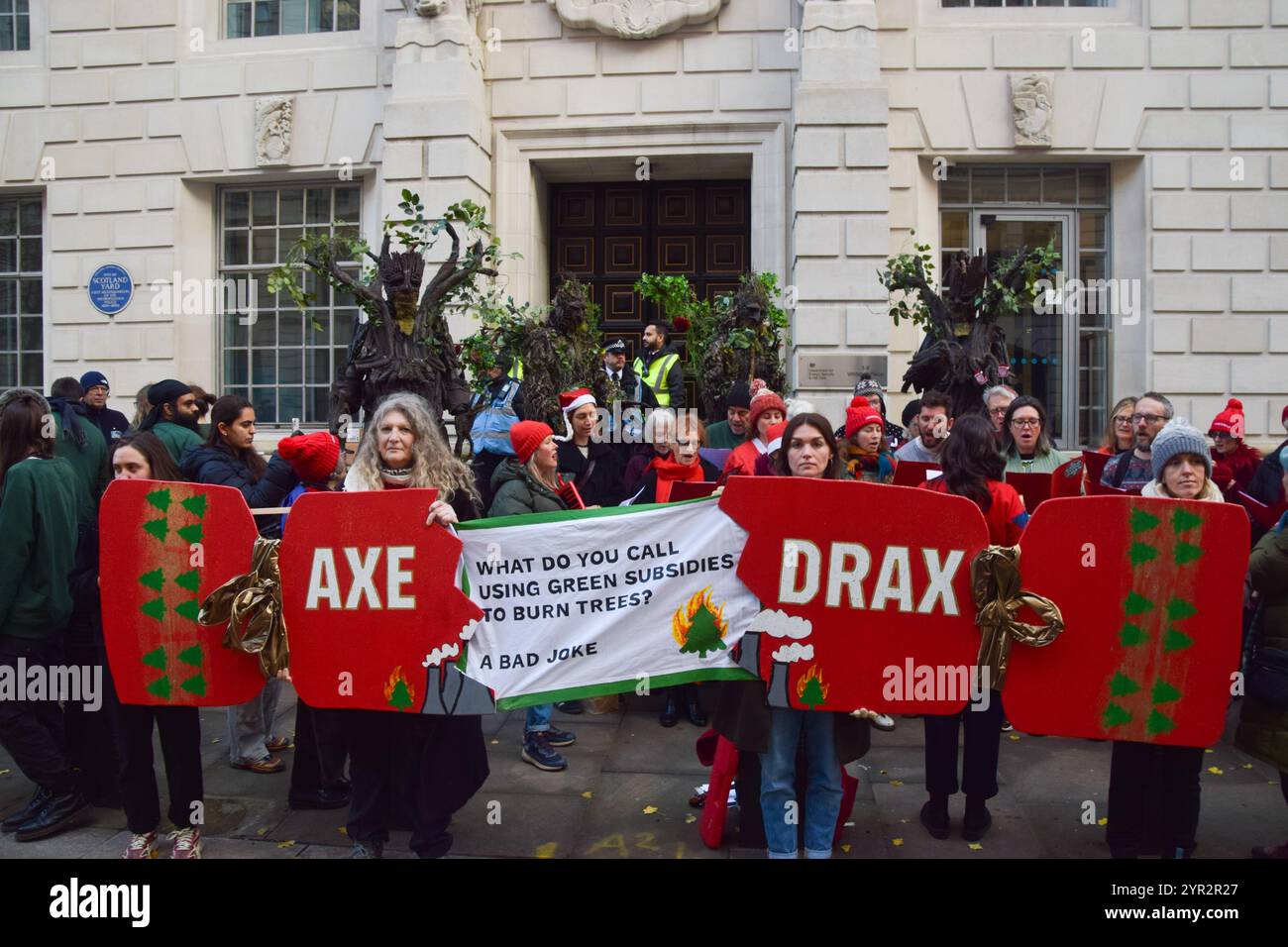 Protesters hold a Christmas-cracker-shaped 'Axe Drax' sign and ...