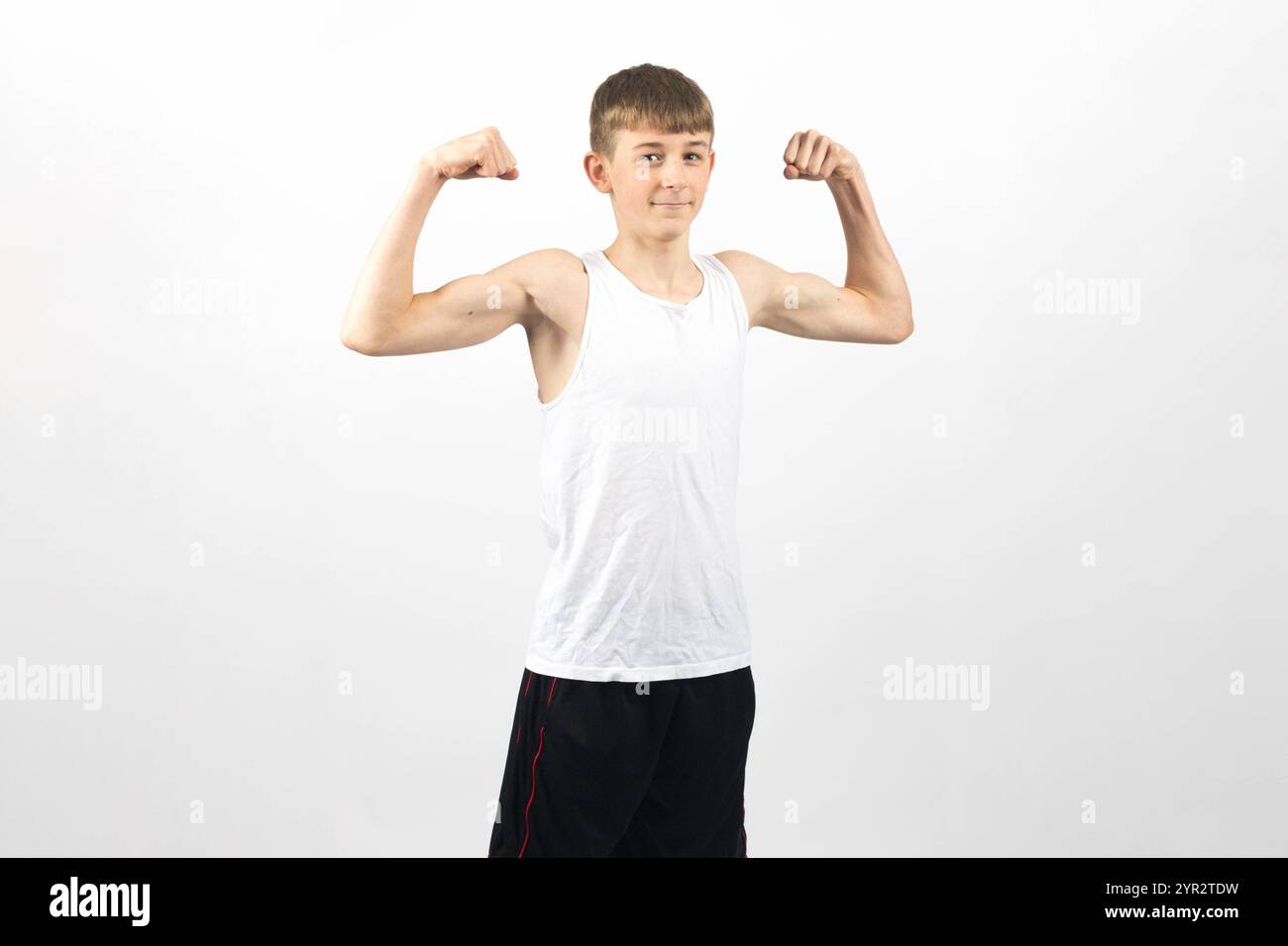 Fifteen year old teenage boy flexing his arm muscles, studio shot ...