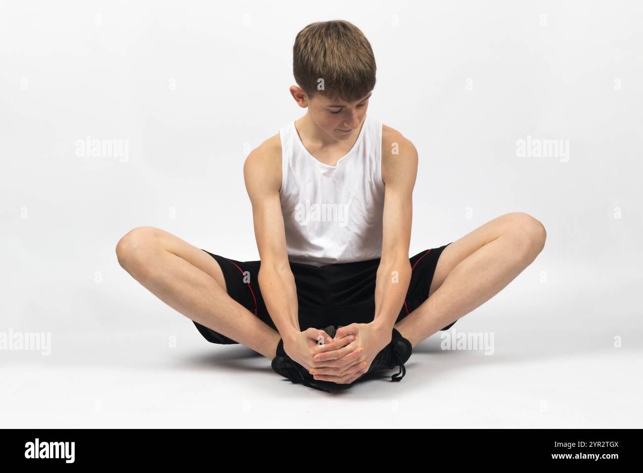 Fifteen year old teenage boy doing butterfly splits, studio shot ...