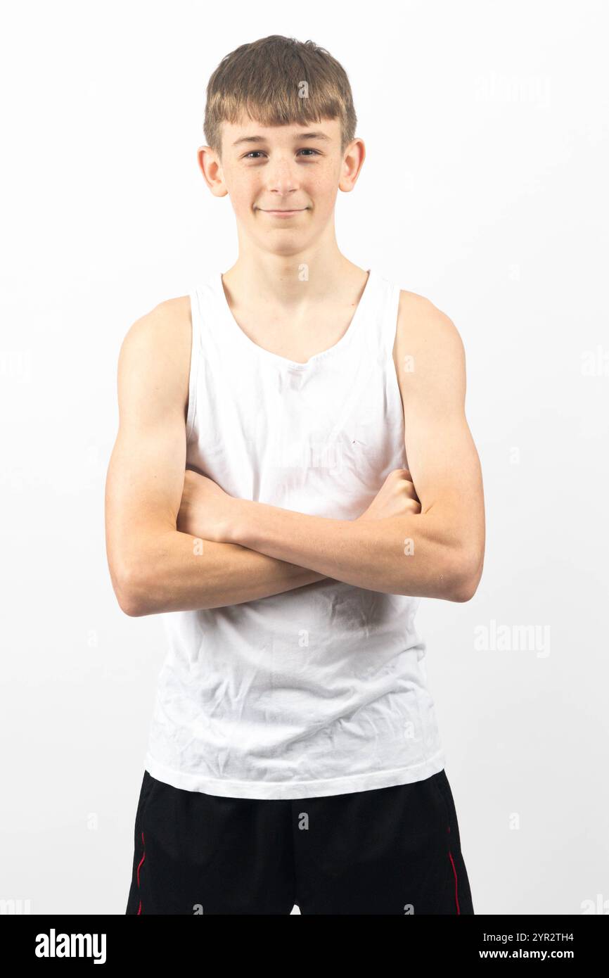 Fifteen year old teenage boy with folded arms, studio shot against a ...