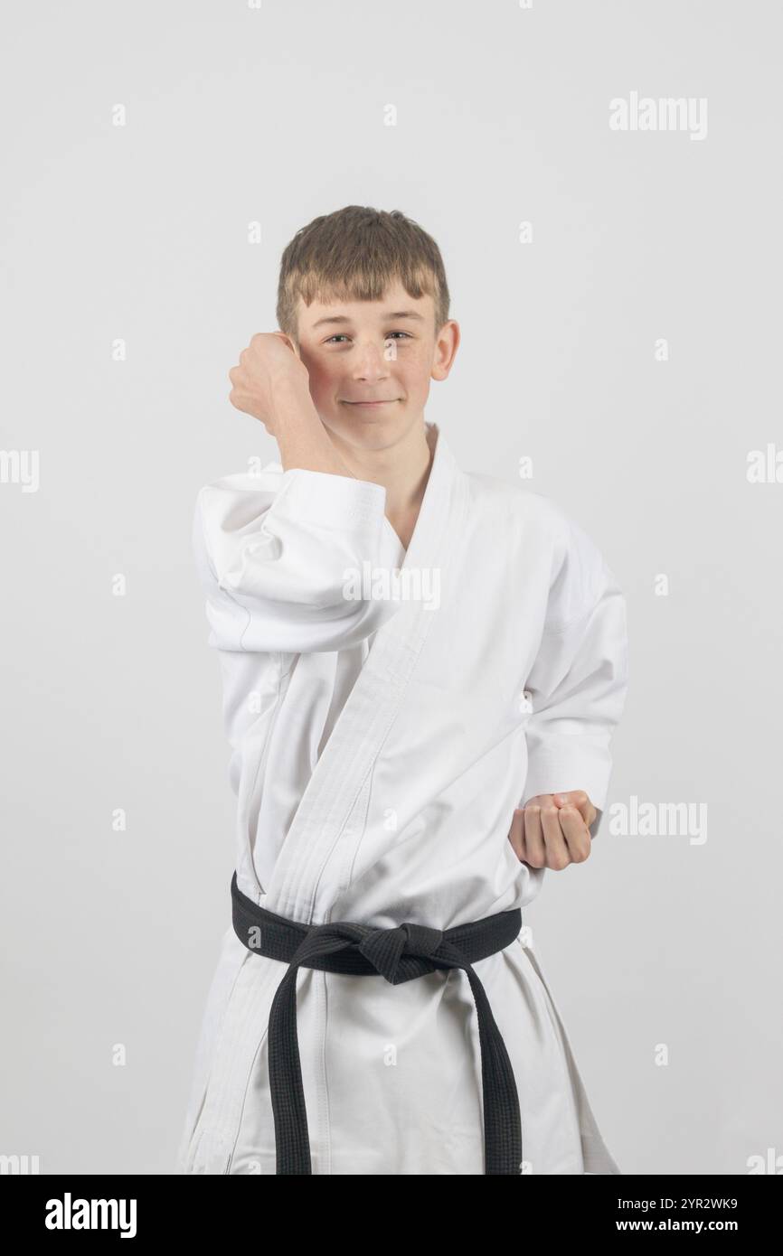 Fifteen year old male teenage karate black belt performing a rising ...