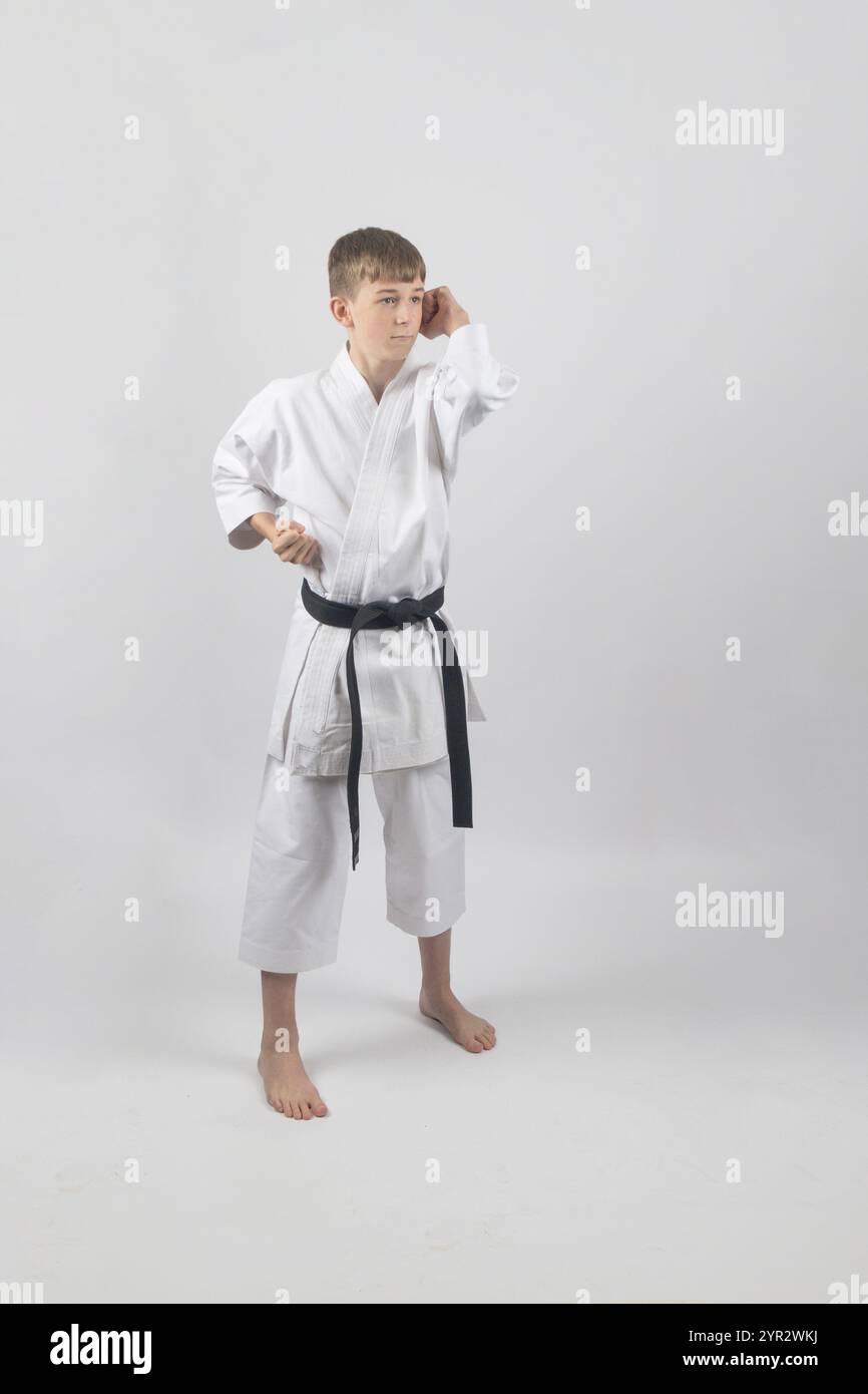 Fifteen year old male teenage karate black belt performing a rising ...