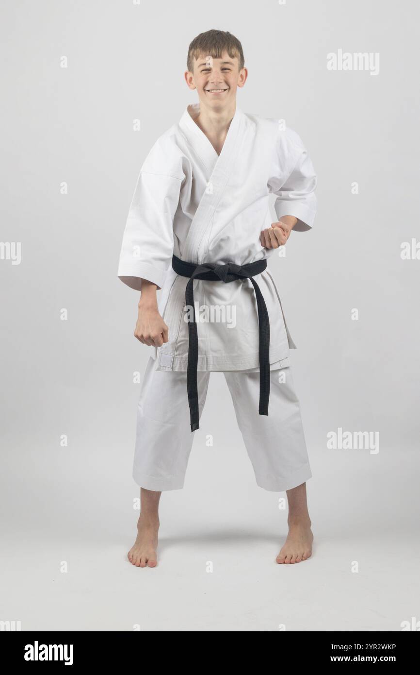 Fifteen year old male teenage karate black belt performing a downward ...