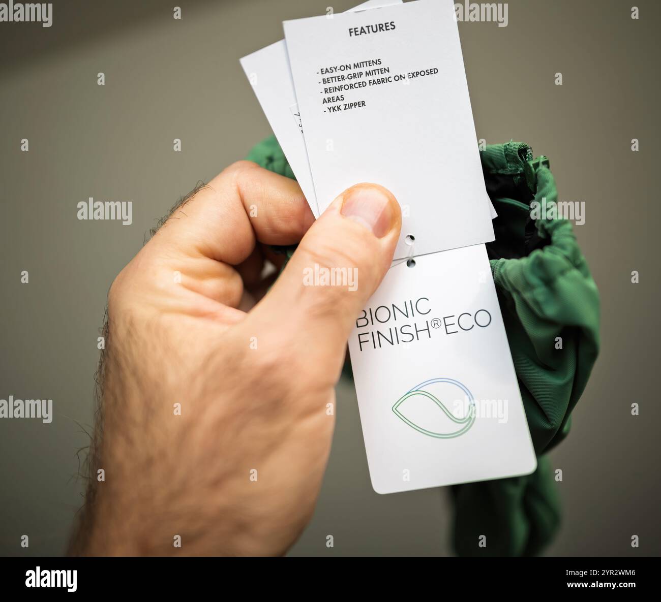 Paris, France - Dec 1, 2024: Close-up of a hand holding a product tag ...