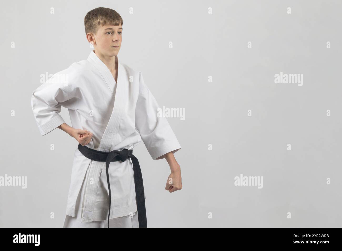 Fifteen year old male teenage karate black belt performing a downward ...