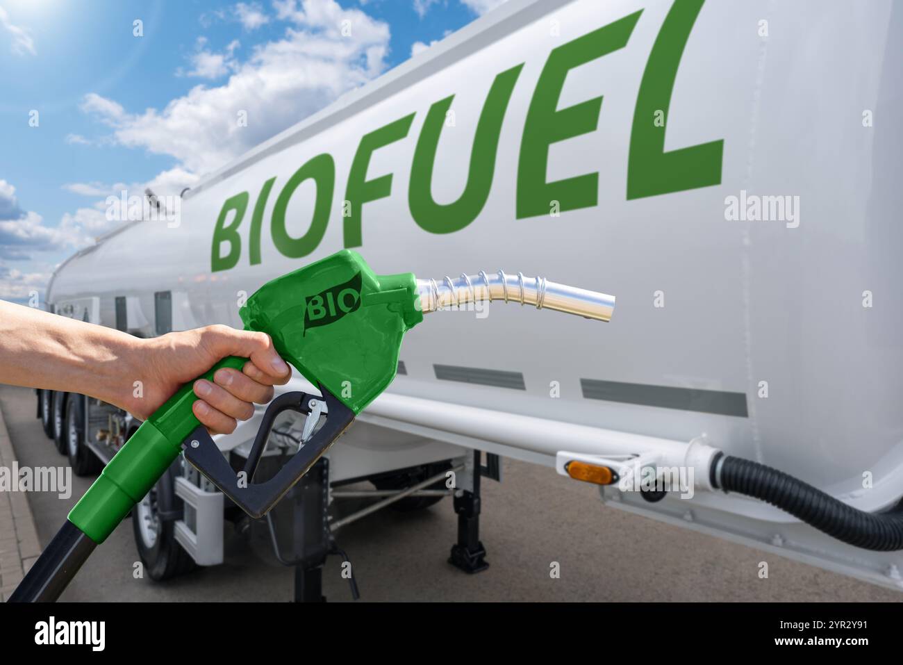 Hand with fuel nozzle with inscription BIO on a background of tank ...