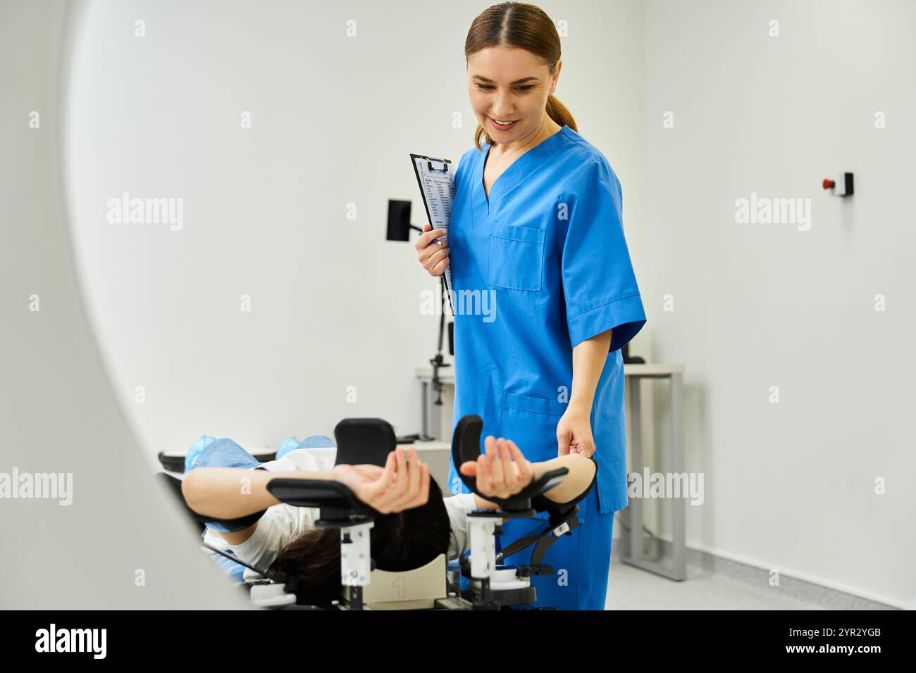 A dedicated doctor in a lab coat supports her patient on the MRI ...