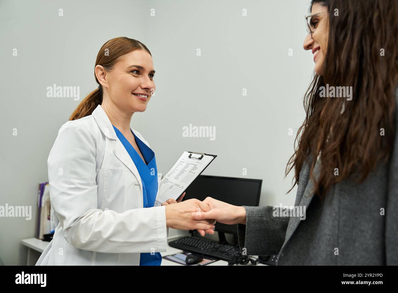 A gynecologist in a lab coat discusses health issues with a female ...