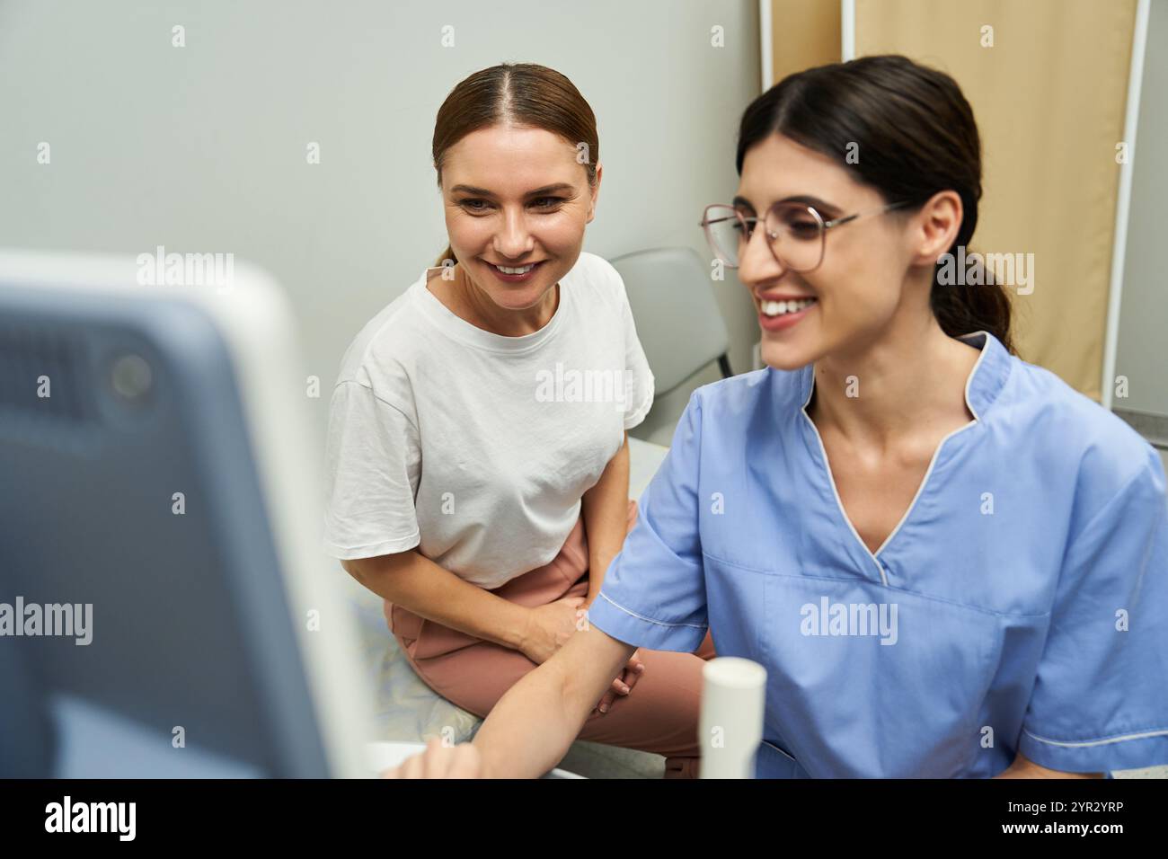 A gynecologist interacts with a patient during a diagnostic visit in a ...