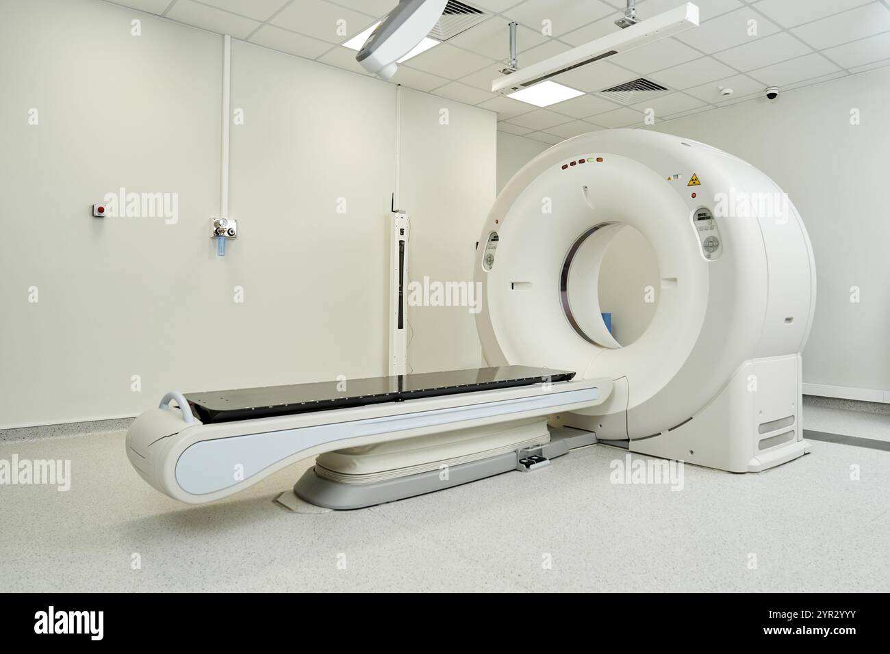 A pristine hospital room showcases a state-of-the-art MRI machine ready ...