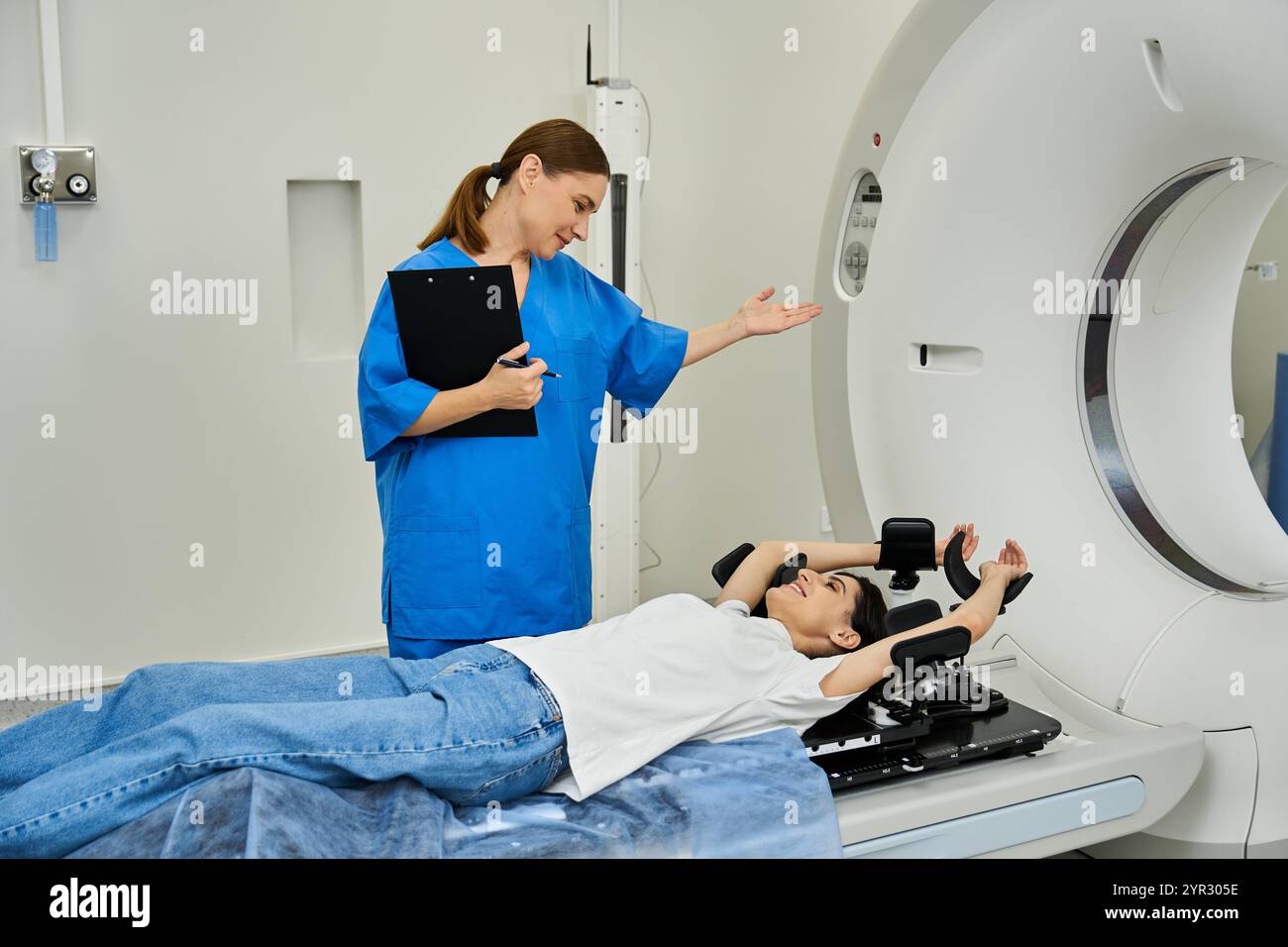 Doctor discusses MRI scanning process with patient lying in machine as ...