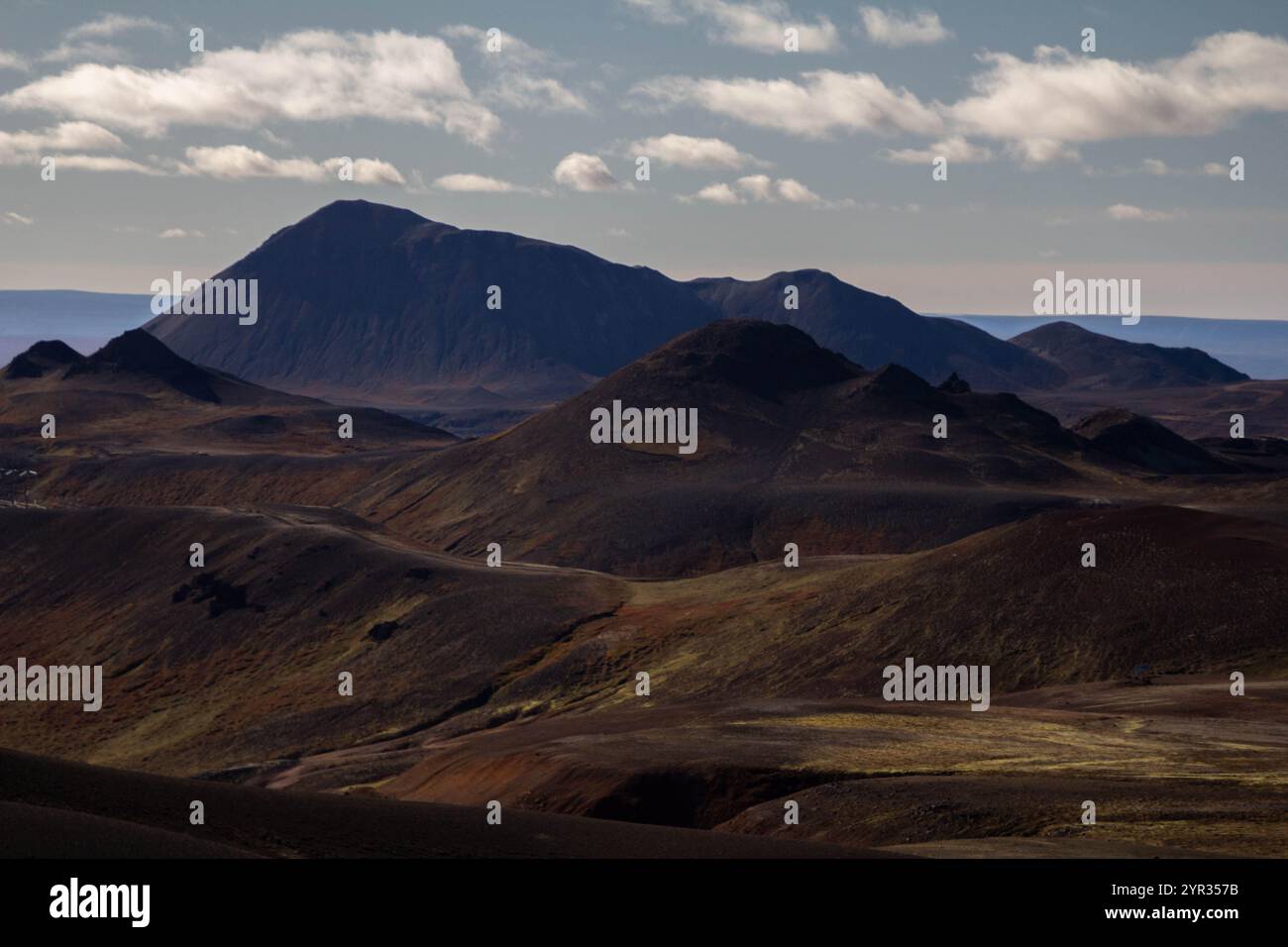 A breathtaking Icelandic landscape with towering mountains, fields, and ...