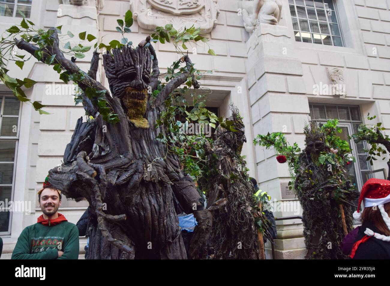 London, UK. 2nd December 2024. Protesters dressed as humanoid trees ...