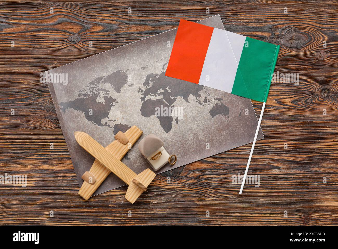 Flag of Ireland, world map, wedding rings and toy plane on wooden ...