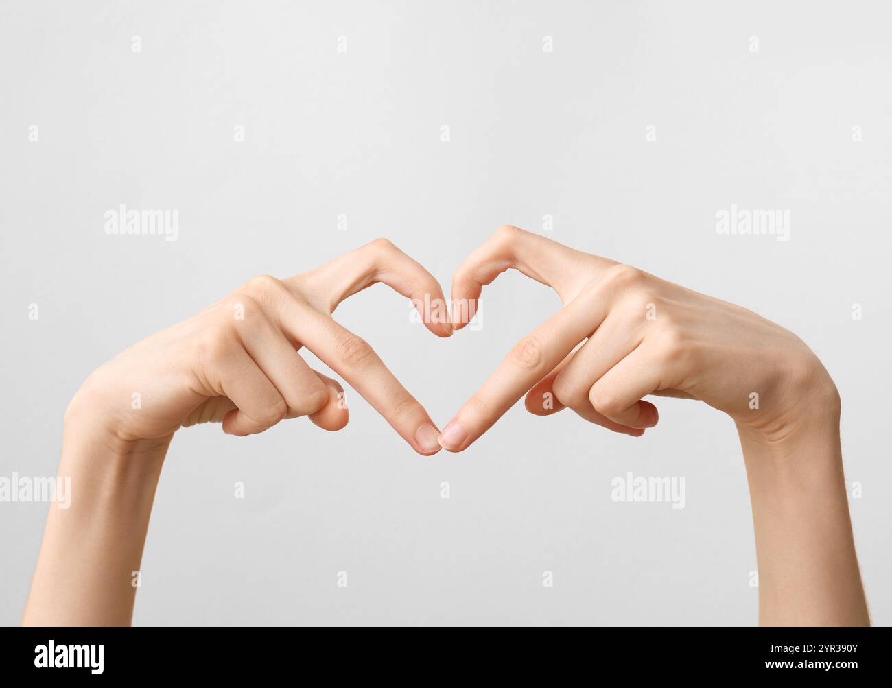 Female hands showing heart gesture on white background Stock Photo - Alamy