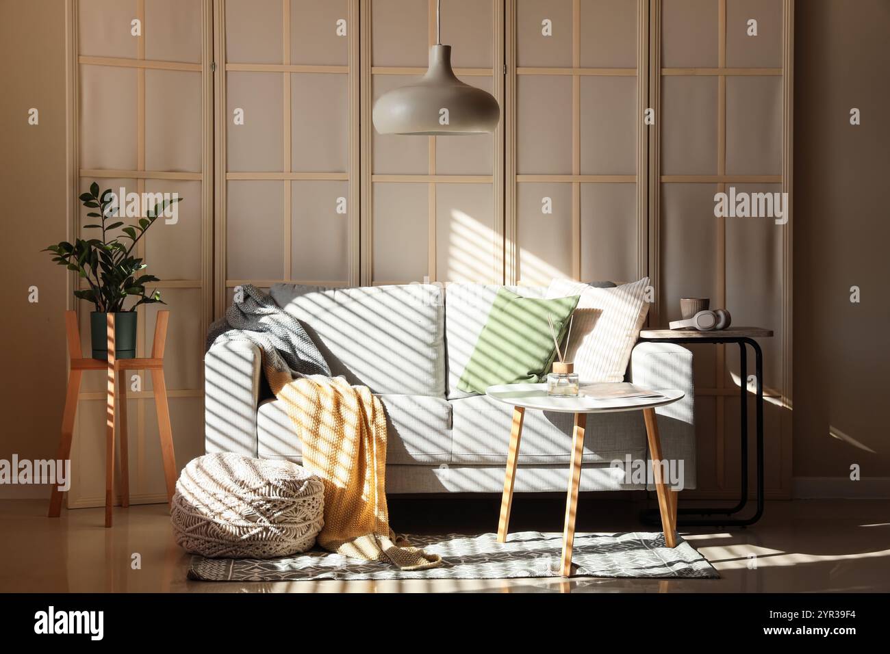 Interior of living room with folding screen, sofa and table Stock Photo ...