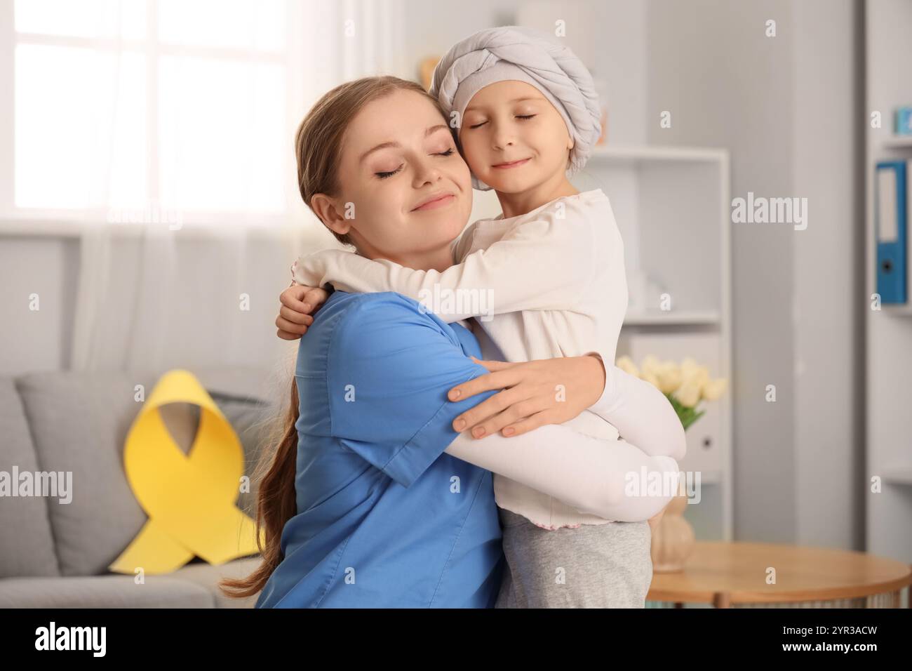 Little girl after chemotherapy with nurse hugging in clinic. Childhood ...