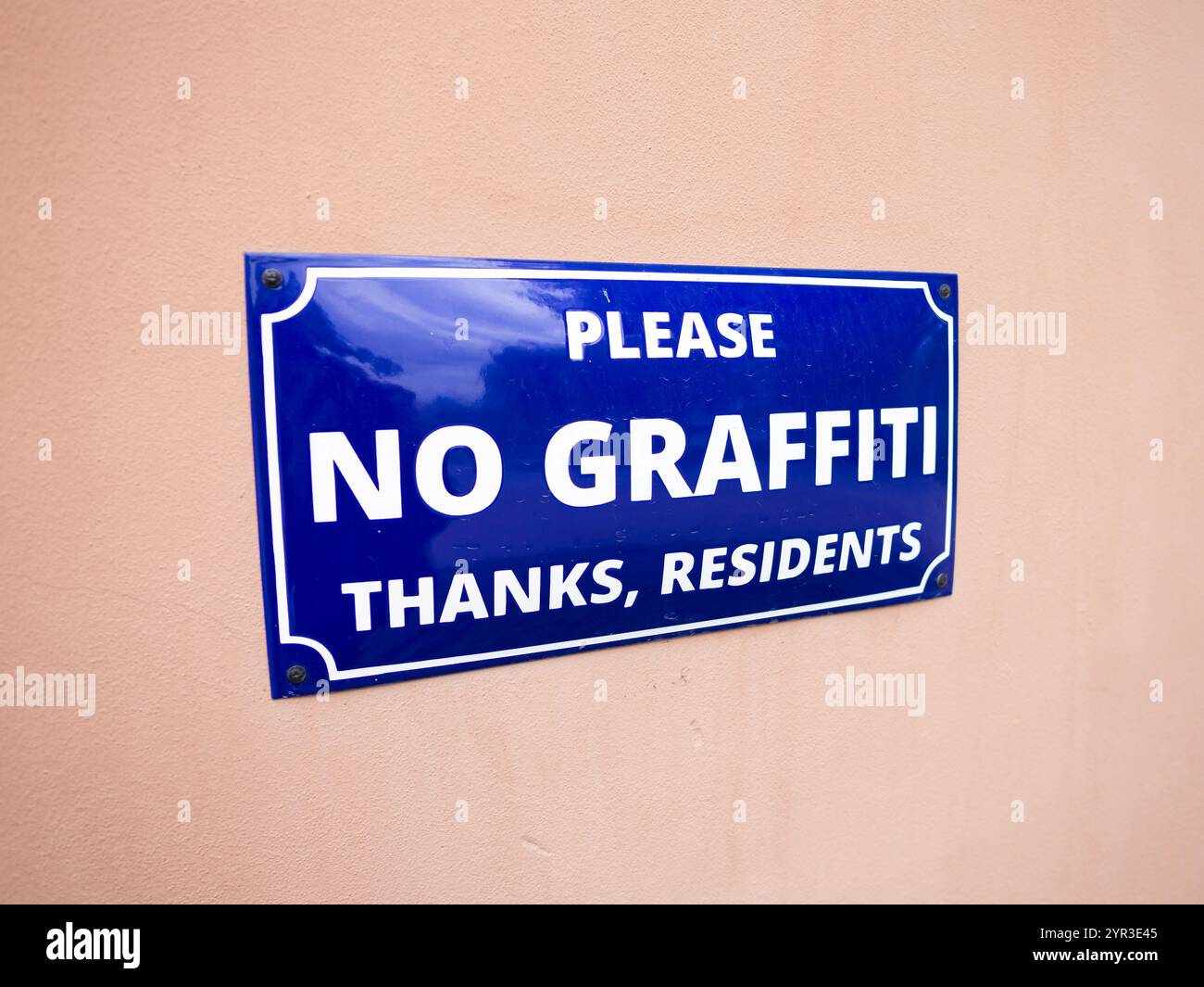 No Graffiti sign on a building wall. A blue signage on a residential ...