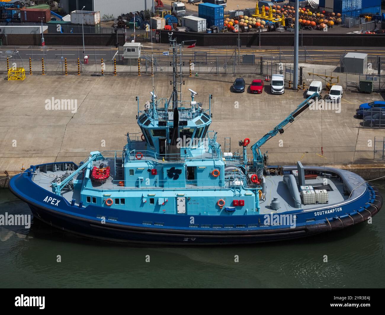 The vividly blue painted 38 metre tug boat, Apex, moored at the docks ...