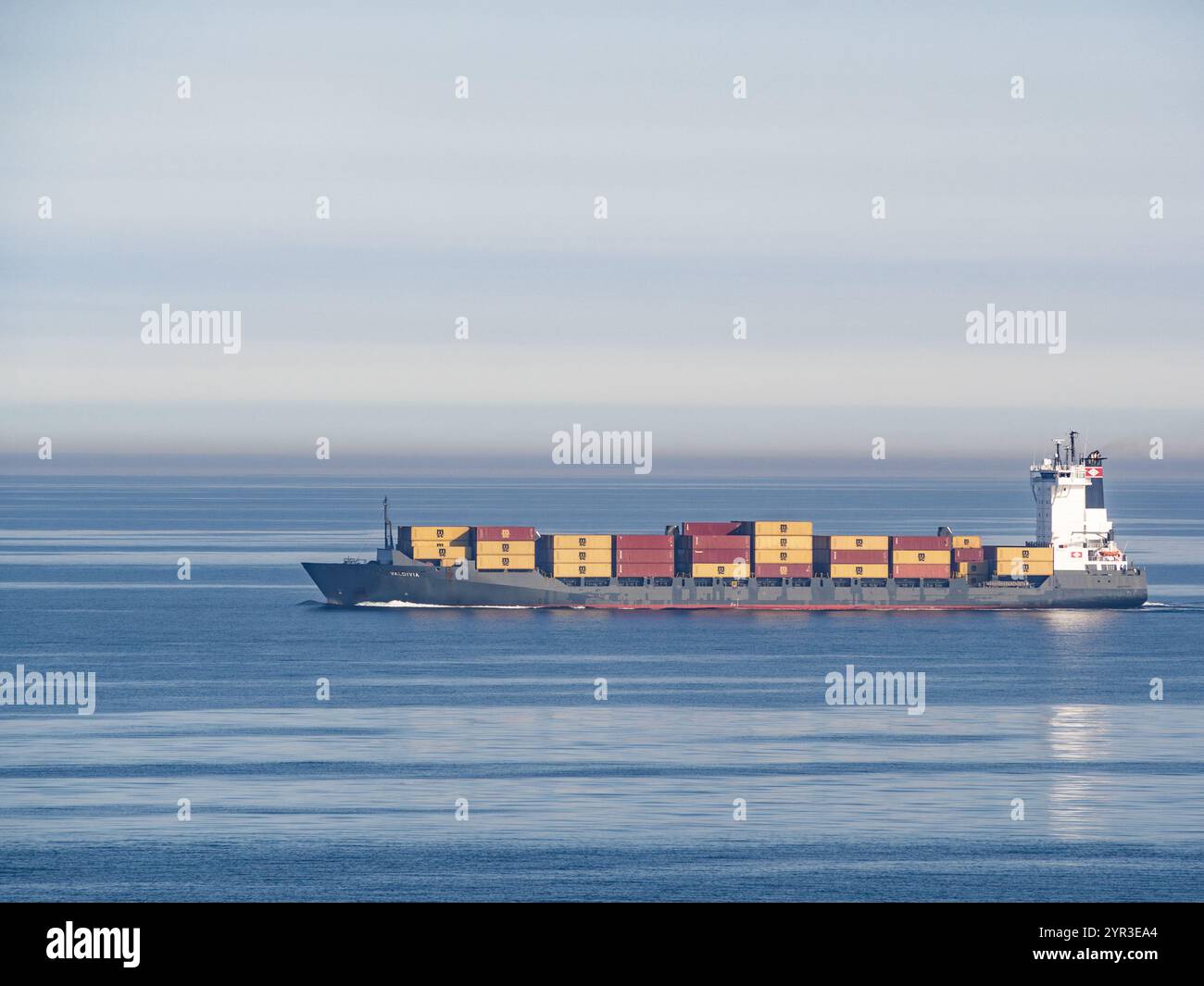 The container vessel, Valdivia stacked with red and yellow shipping ...