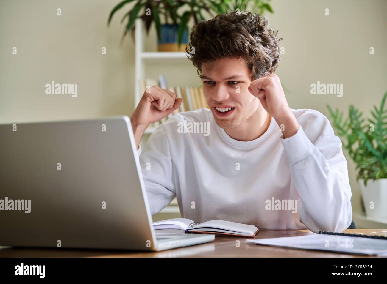 Happy young guy looking at computer, emotion of joy victory, hand ...