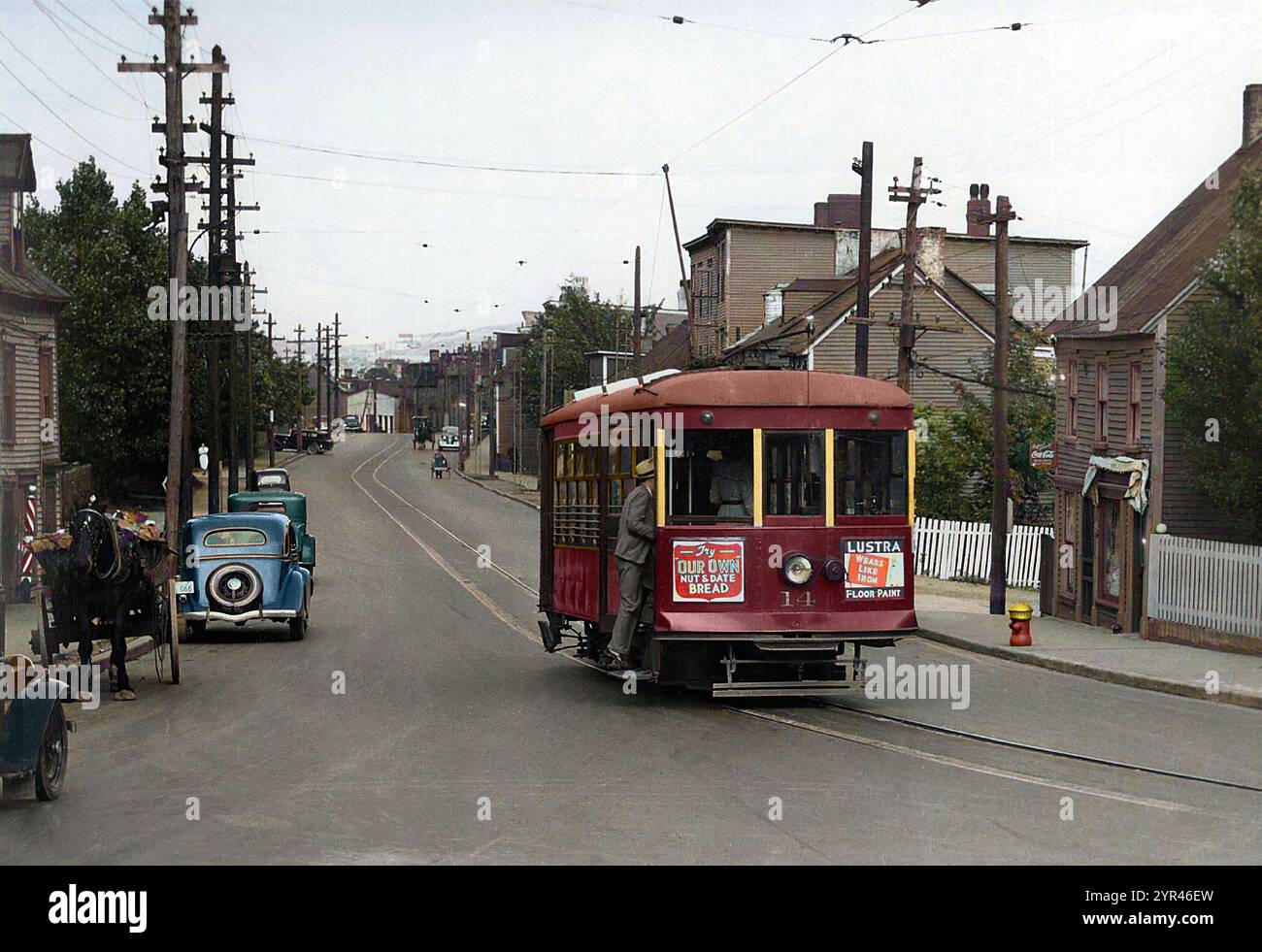 A vintage red streetcar travels along a historical city street lined ...