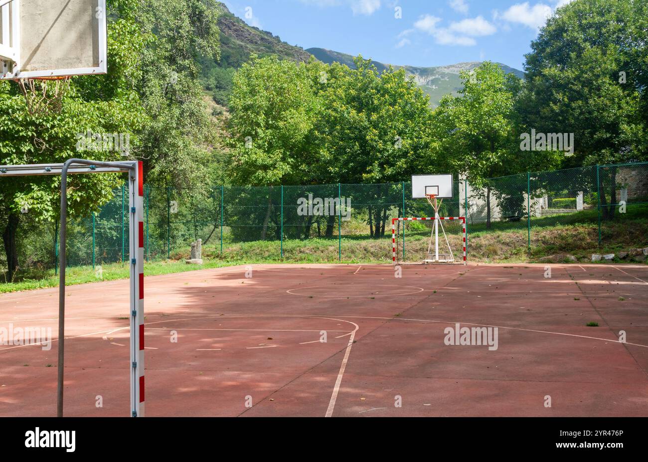 A low-angle perspective captures a white net draped from a red rim, set ...
