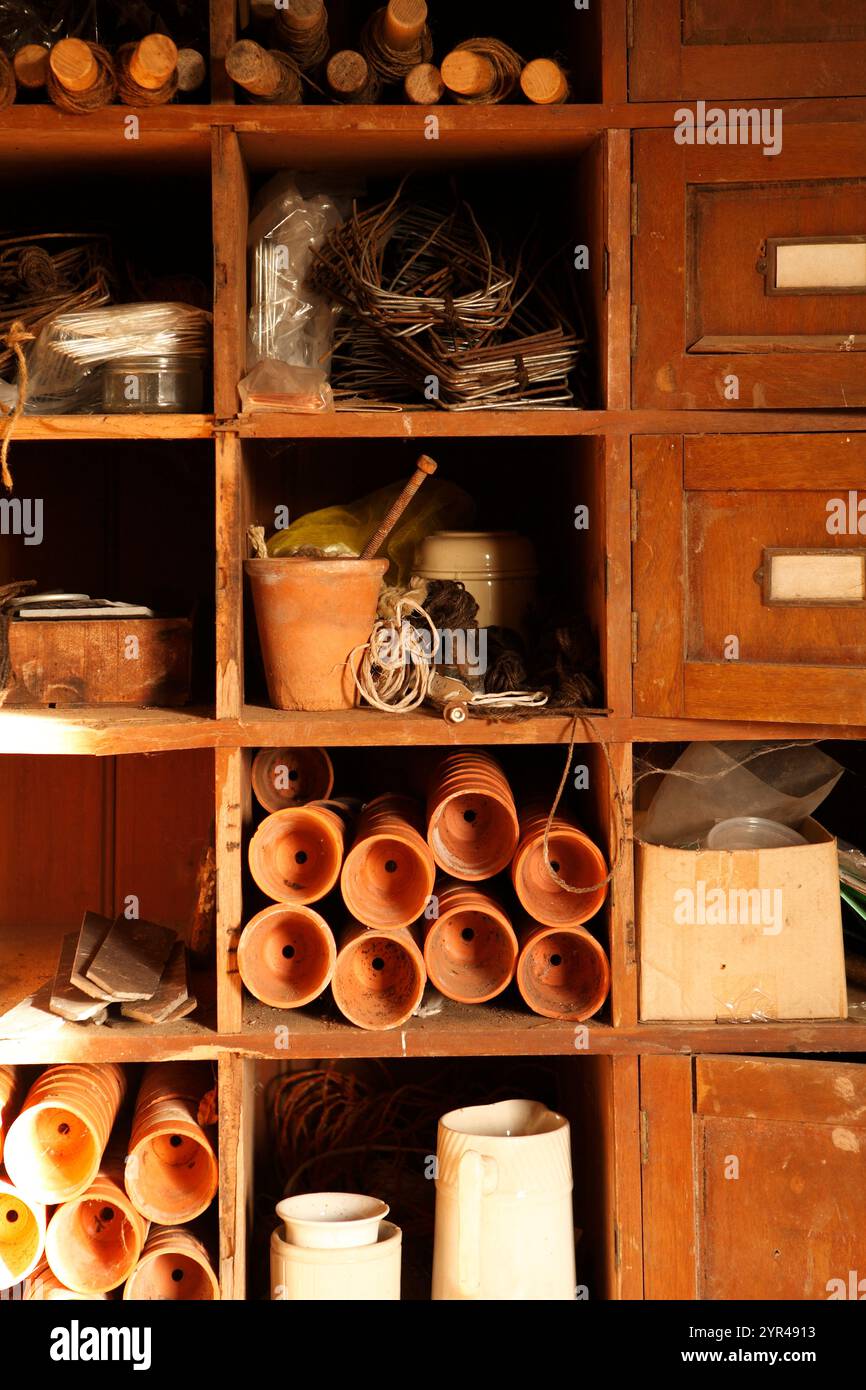 Inside a Gardeners cupboard, on box shelving, terracotta pots, string ...