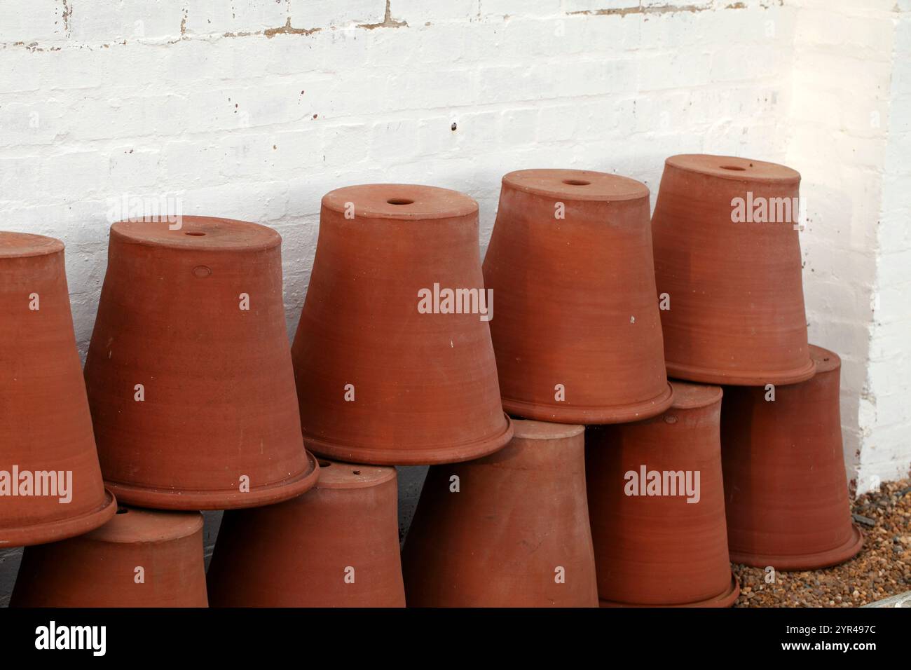 Stacked terracotta pots in a garden, upside down to fully drain and ...