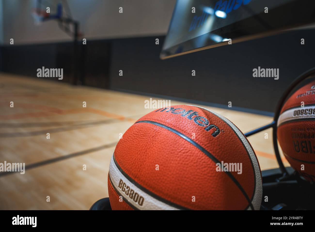 A Molten basketball rests on a cart in an indoor sports facility. The ...