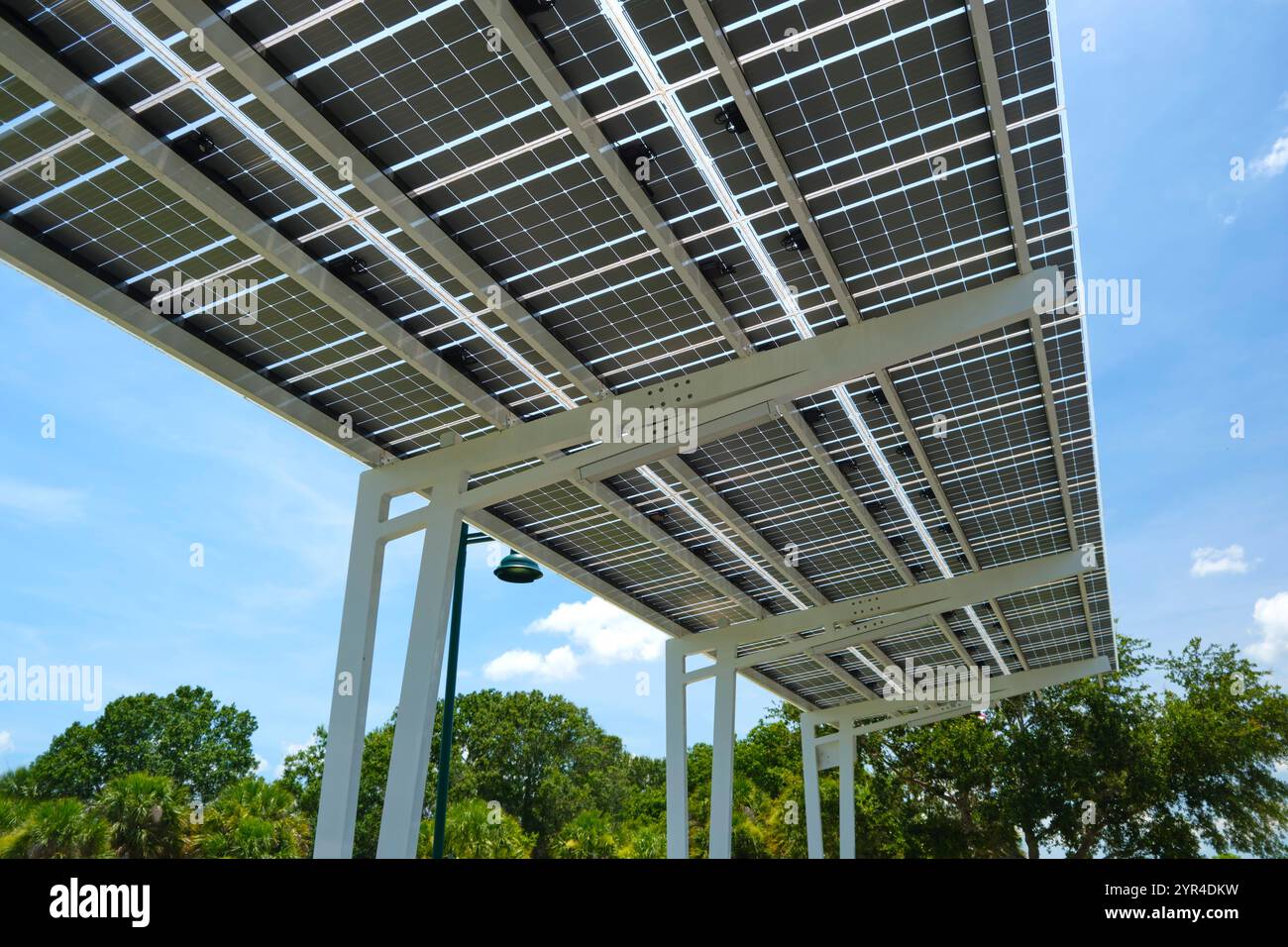 Solar panels installed as shade roof over parking lot for parked ...