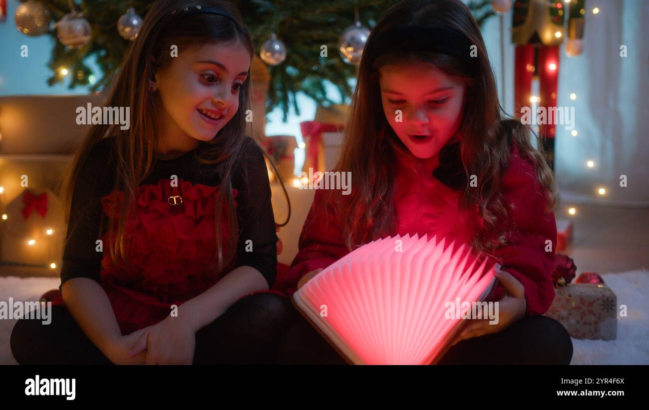 Little girls playing with a magic book Stock Photo - Alamy